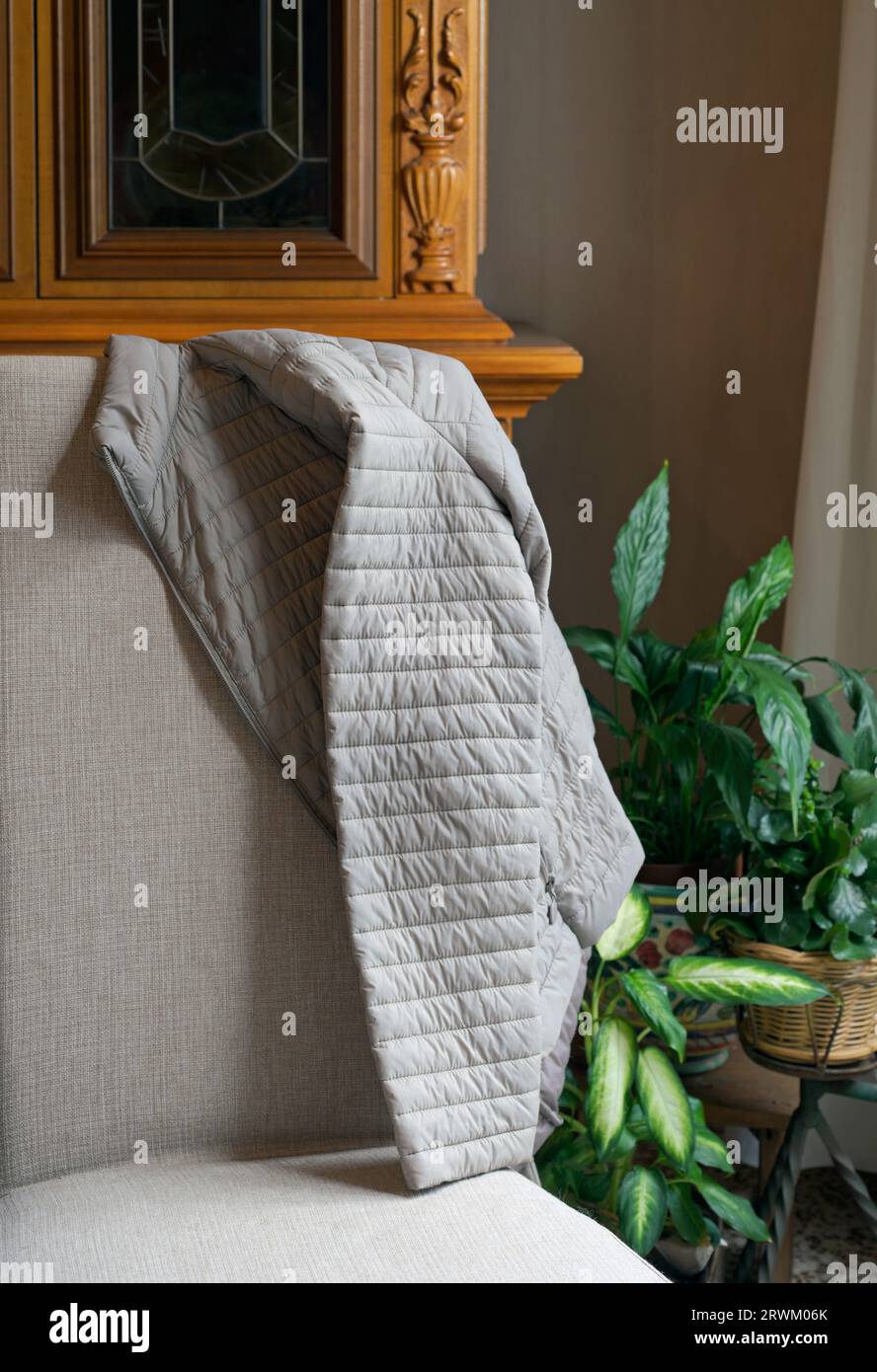 padded jacket hanging on chair in living room Stock Photo - Alamy