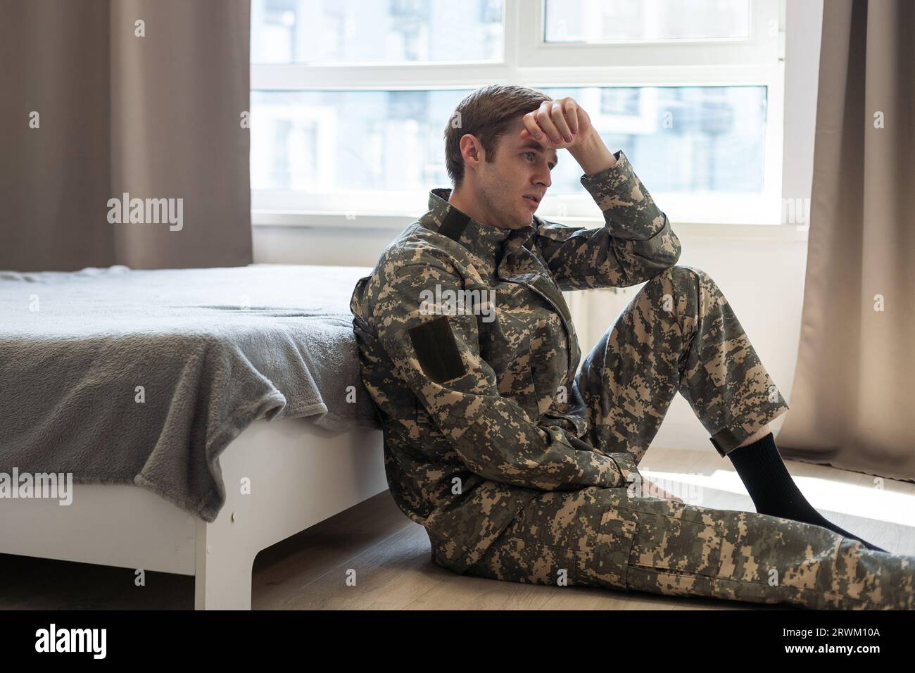 Stressed veteran soldier engrossed in depressive thoughts and memories ...