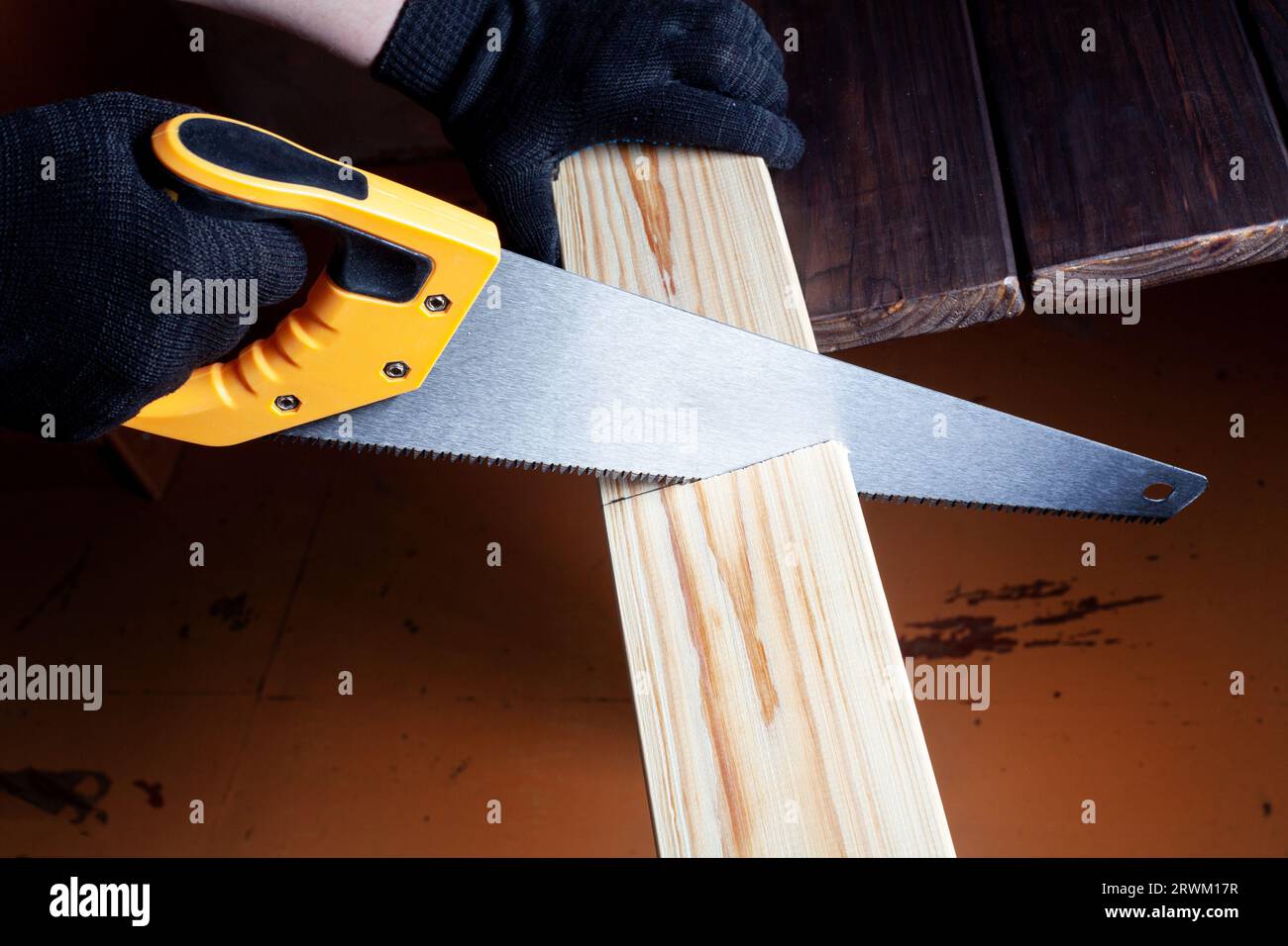 Close up the man use hand saw cutting wood board in the carpenter shop ...