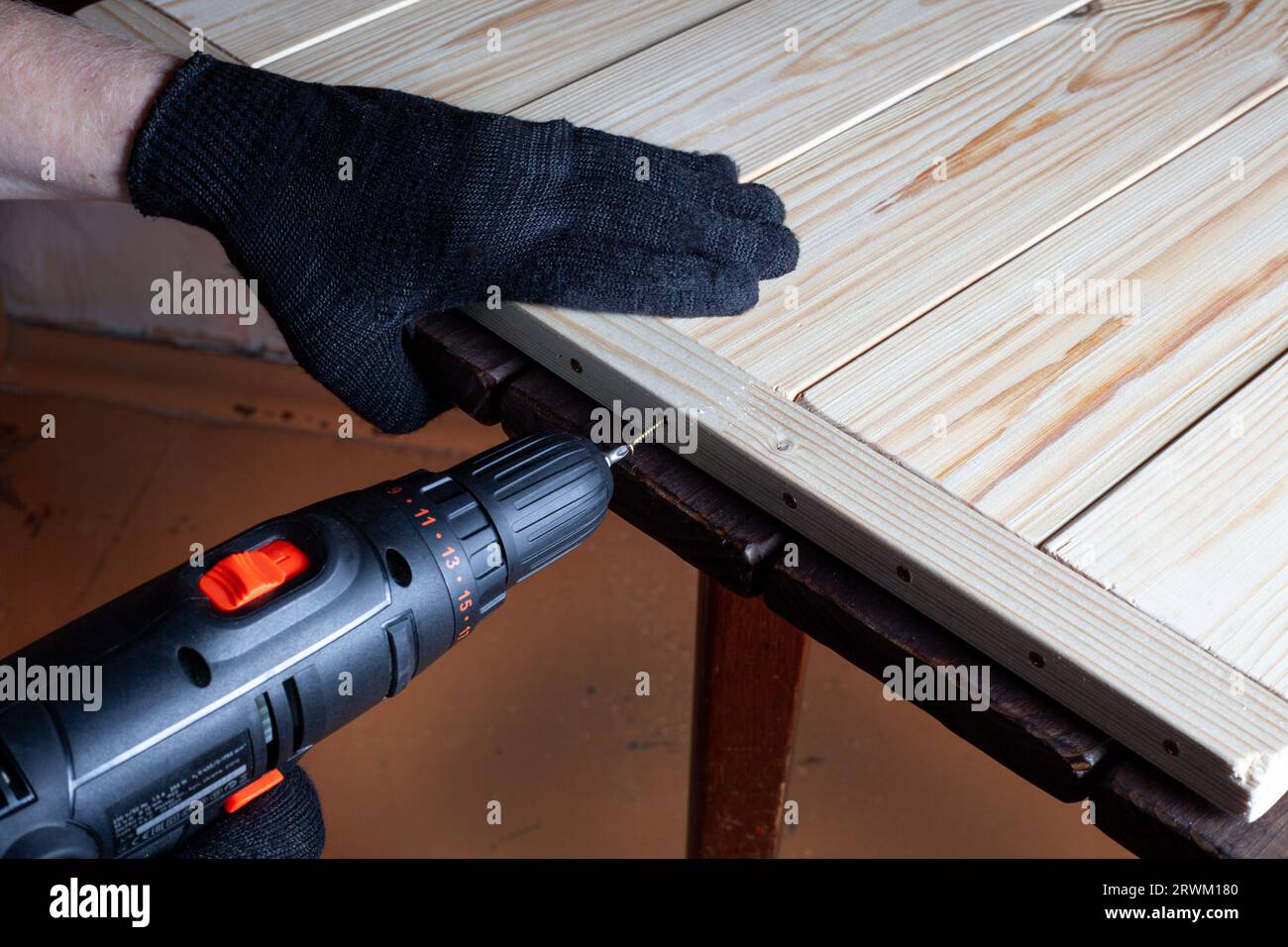 Carpentry work. The self-tapping screw is screwed into a wooden beam ...