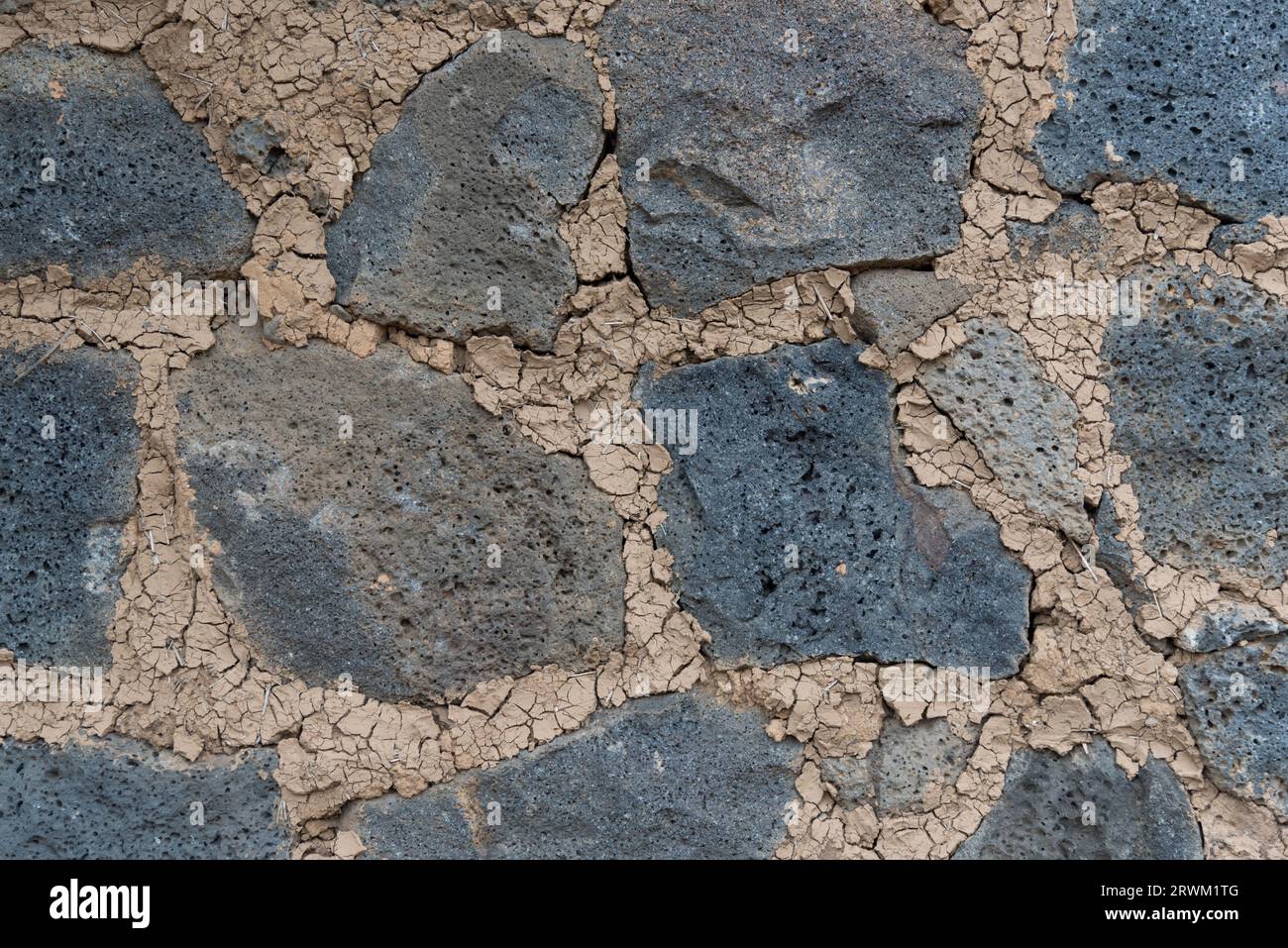 Close-up of a wall made of stones/ rocks and mud. The olden day method ...