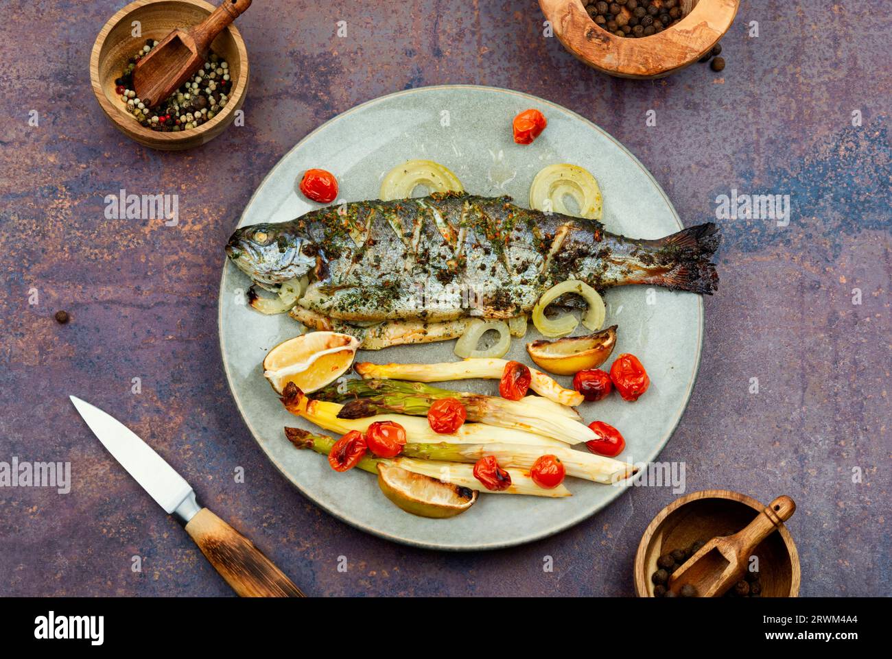 Grilled whole trout cooked with asparagus. Baked salmon fish served on ...