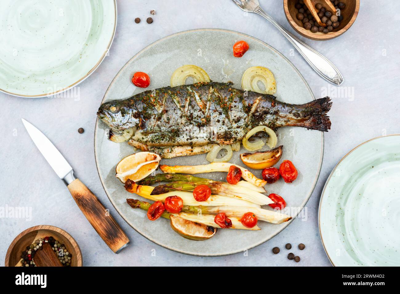 Grilled whole trout cooked with asparagus. Baked salmon fish on a plate ...