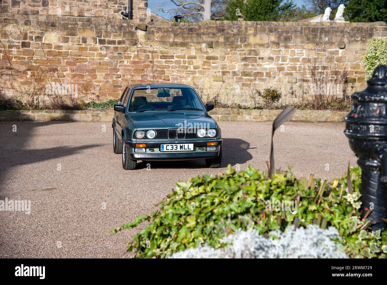 BMW Three Series (E30) four door saloon parked on a gravel courtyard on ...