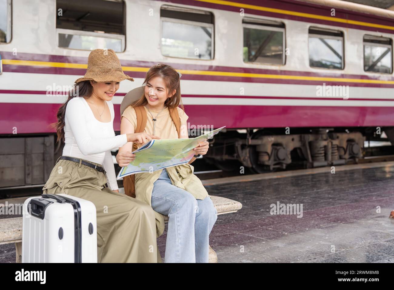 Travel concept. girl friend wear hat holding map have bag and luggage. female traveller waiting ...