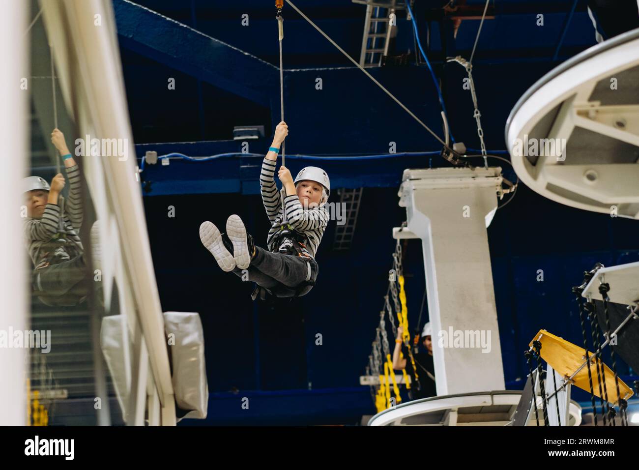 caucasian boy of 8 years old climbing in adventure park passing ...