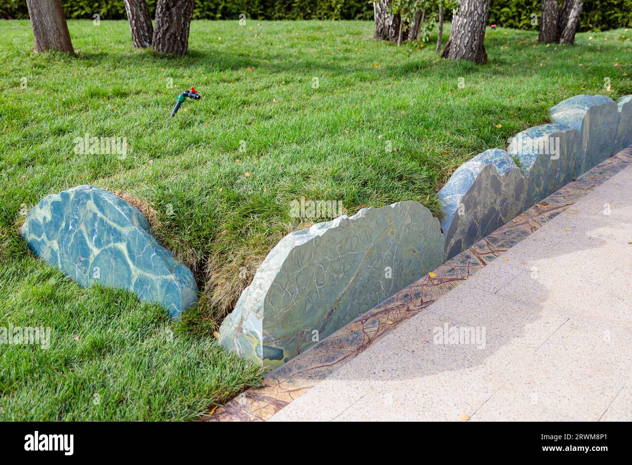 Landscaping, edging the path with boulders of diabase stone Stock Photo ...