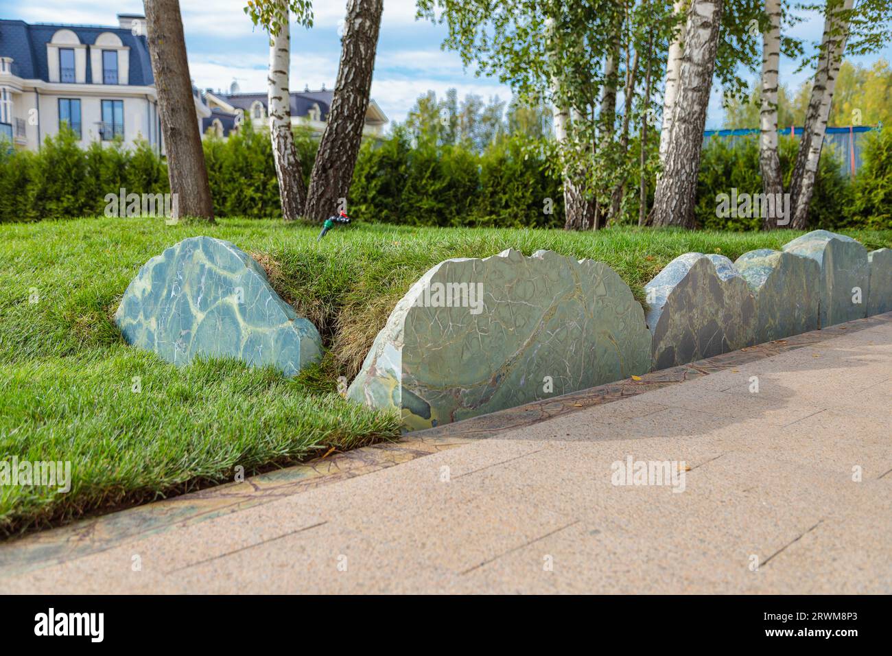 Landscaping, edging the path with boulders of diabase stone Stock Photo ...