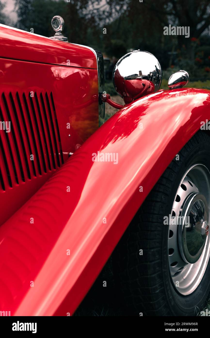 Front side view of vintage red car with long wheel guard and chrome ...