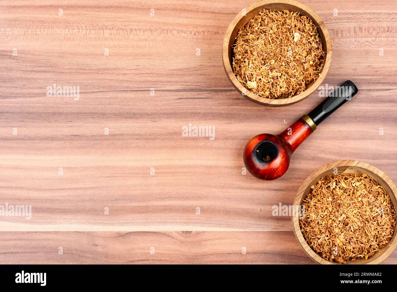 Fragrant smoking tobacco and a smoking tube or pipe on the table. Space ...