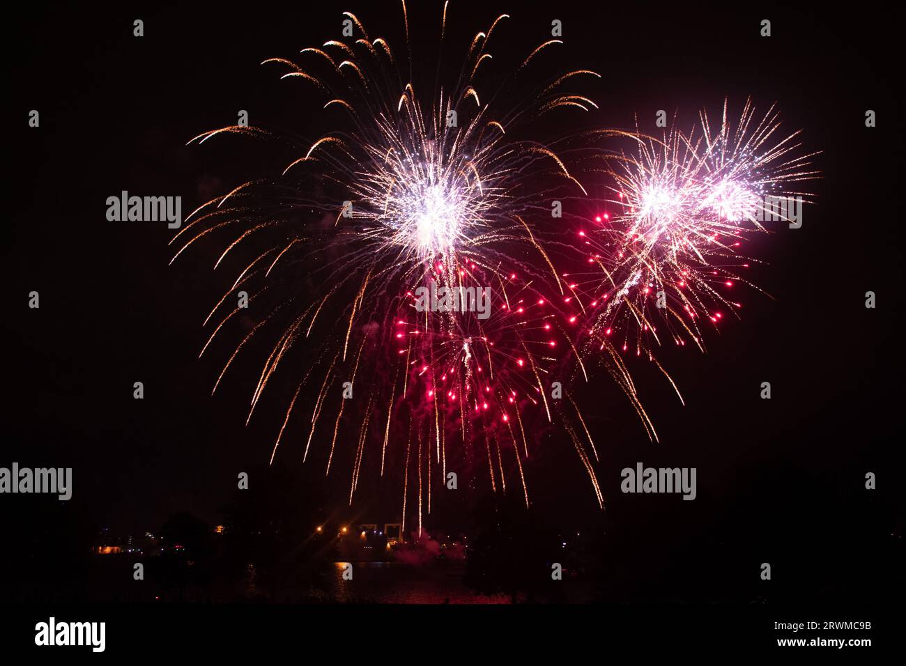 A vibrant display of fireworks lights up the night sky, creating a ...