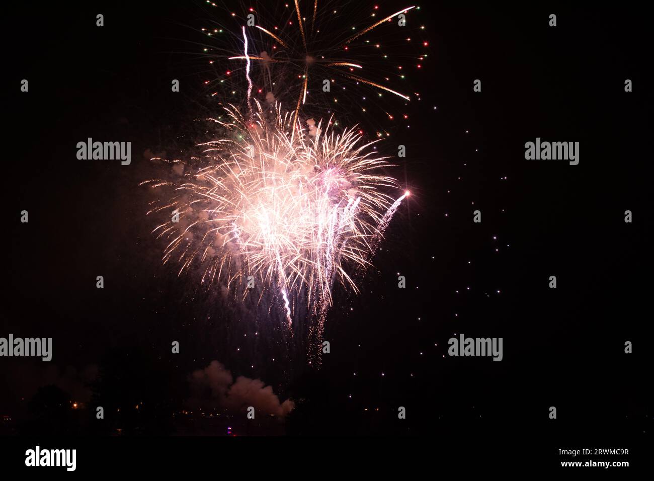 A vibrant display of fireworks lights up the night sky, creating a ...