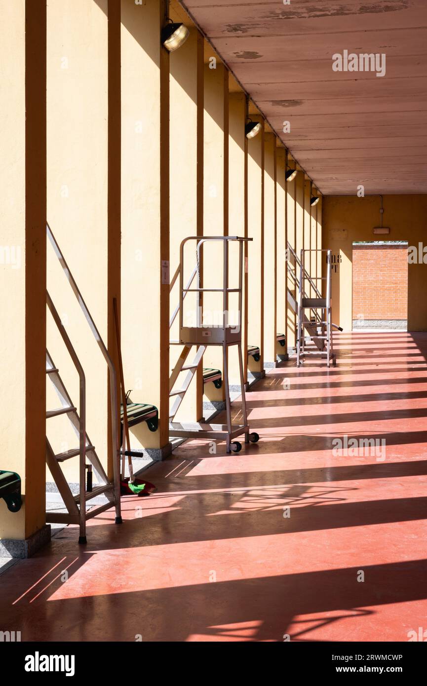 A vibrant yellow corridor with two ladders to either side and a set of ...