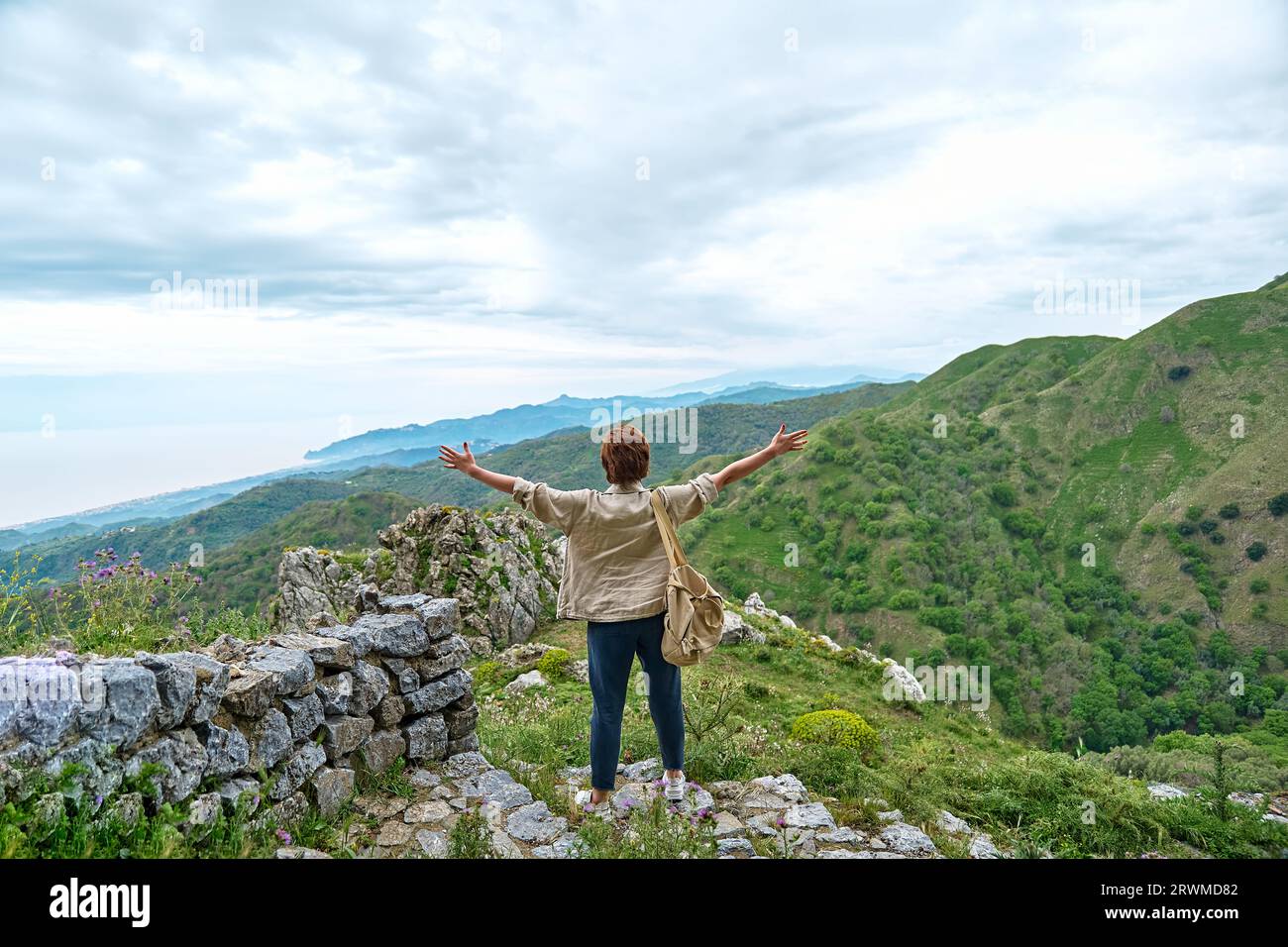 Female traveler spreading arms up to sky enjoying freedom on the pick ...