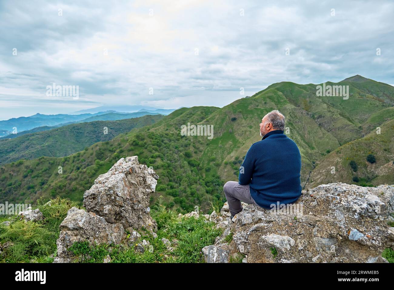 Mature traveler man enjoying freedom on the pick of mountain in front ...