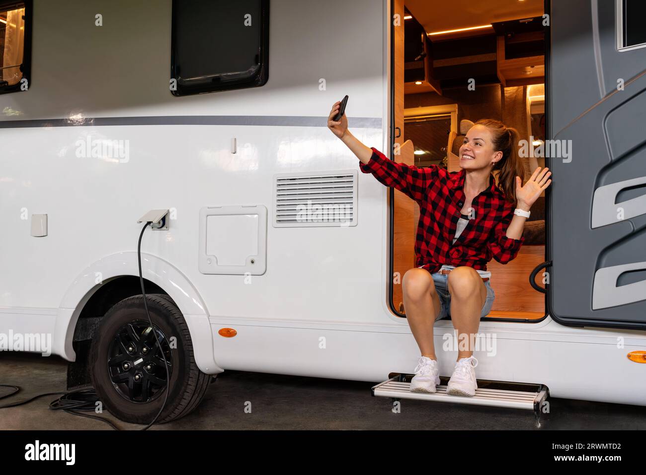 Camper van travel lifestyle, woman takes a selfie using her cellphone ...