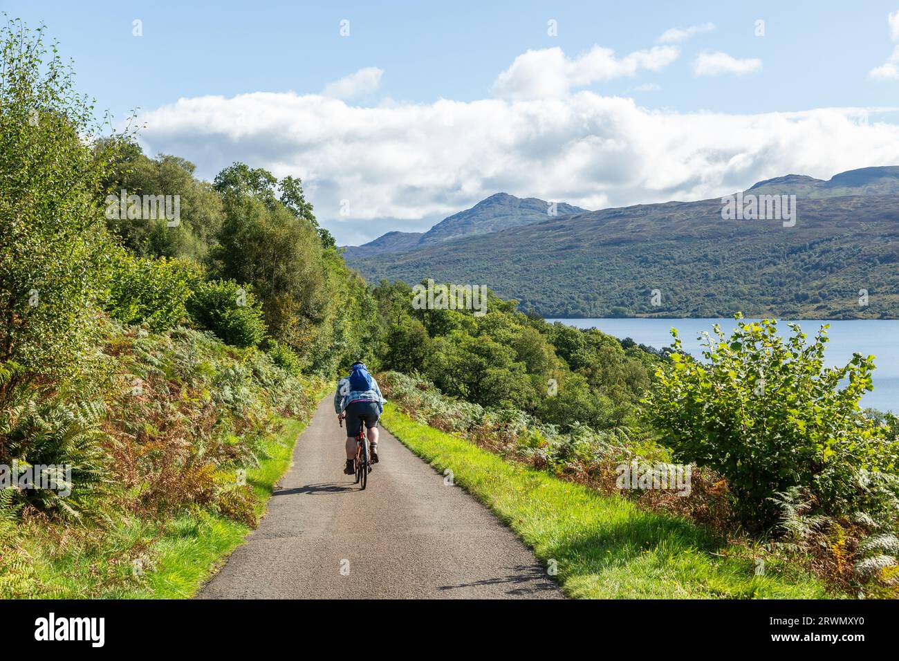 A cyclist on the road next to Loch Katrine in the Trossachs National ...