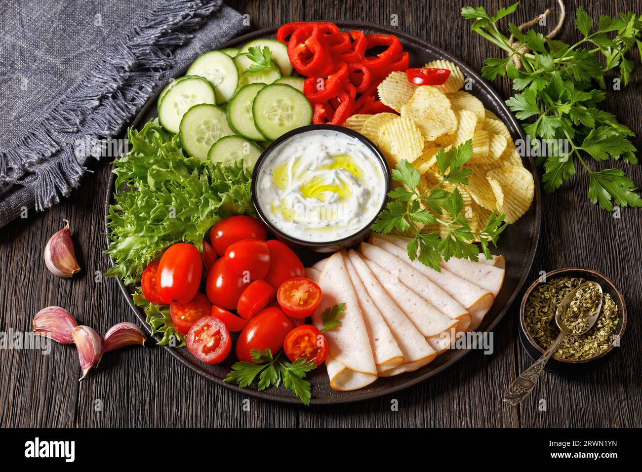 close-up of sliced ham, potato chips, leafy greens and vegetables snack ...