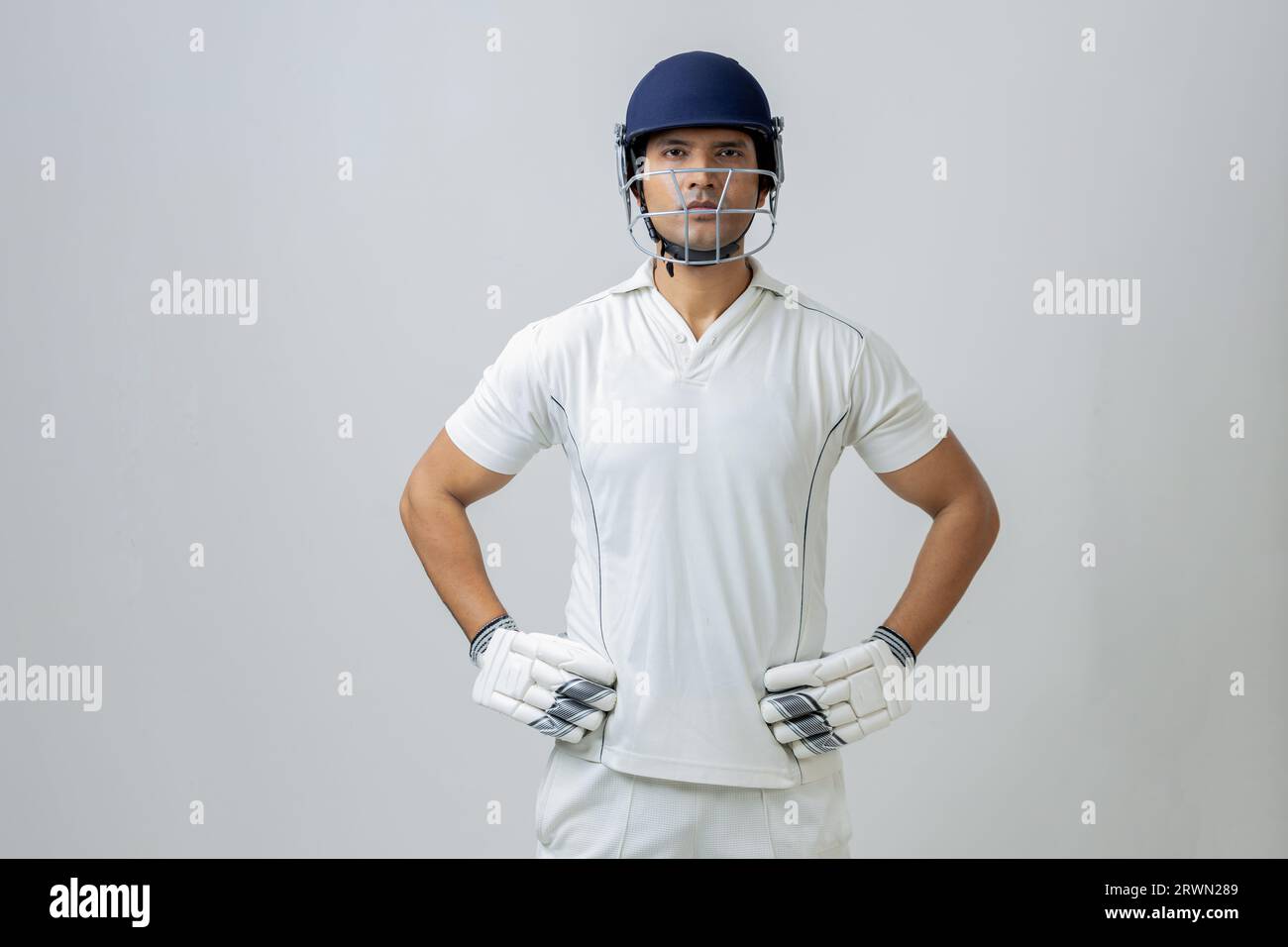 portrait of indian Man in cricket dress with helmet and gloves ...