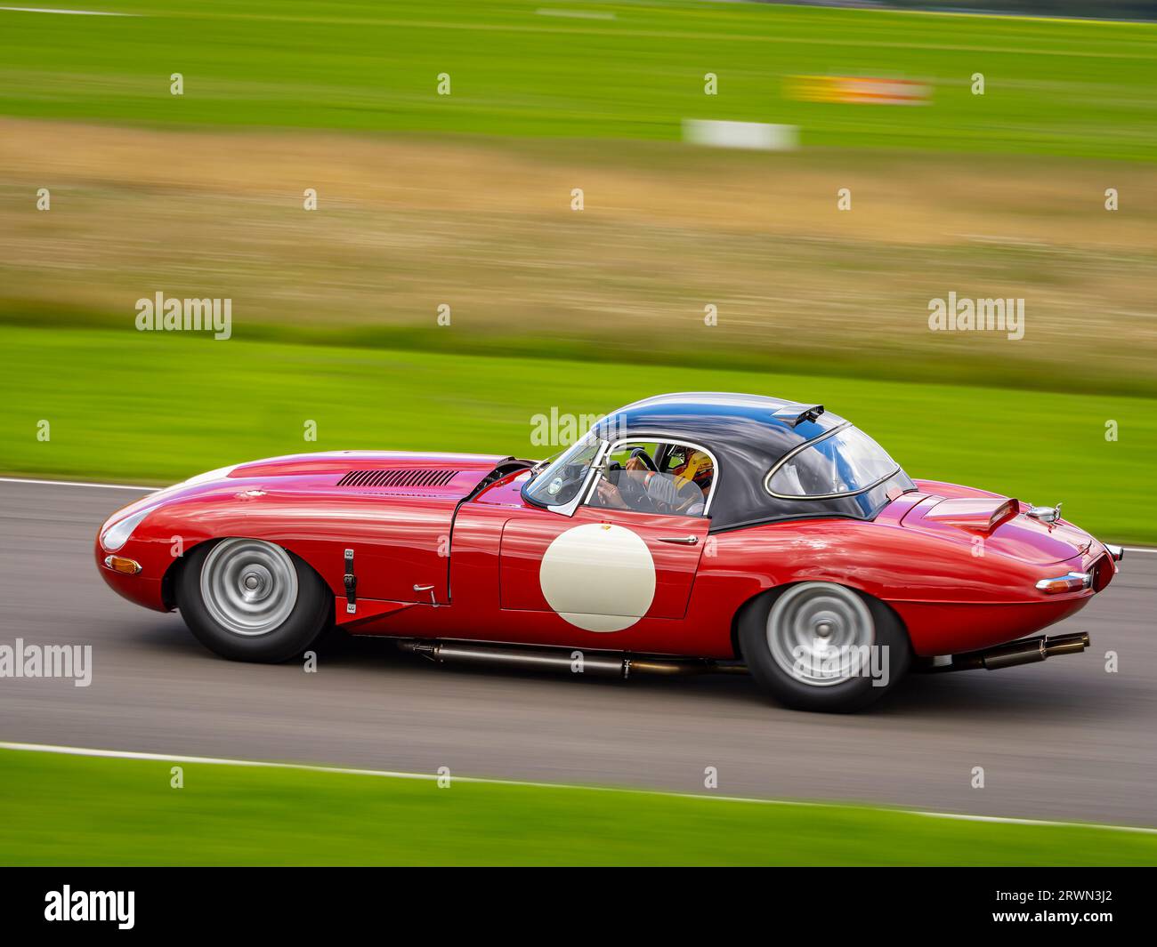A red E type Jaguar testing at the Goodwood motor racing circuit, West ...