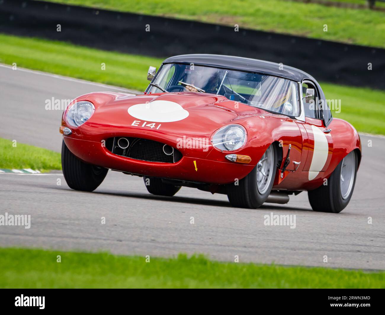 A red E type Jaguar testing at the Goodwood motor racing circuit, West ...