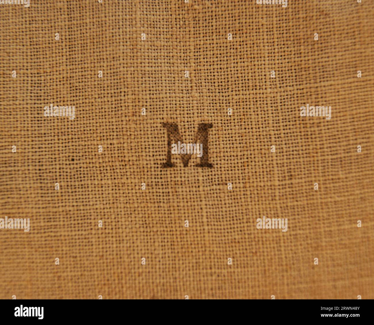 Letter M. Stamp letters on linen fabric Stock Photo - Alamy