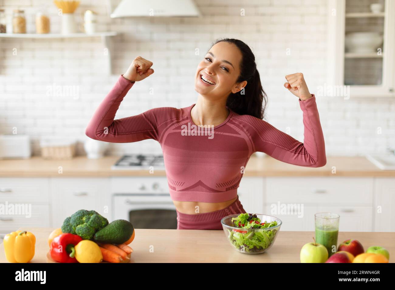 Happy Young Fitness Lady Showing Biceps Muscles While Cooking Indoors ...