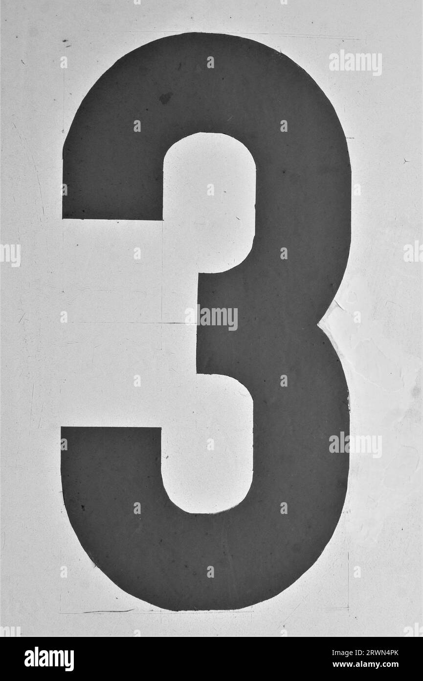 Gray number 3. Number three written on a white wall with gray paint ...