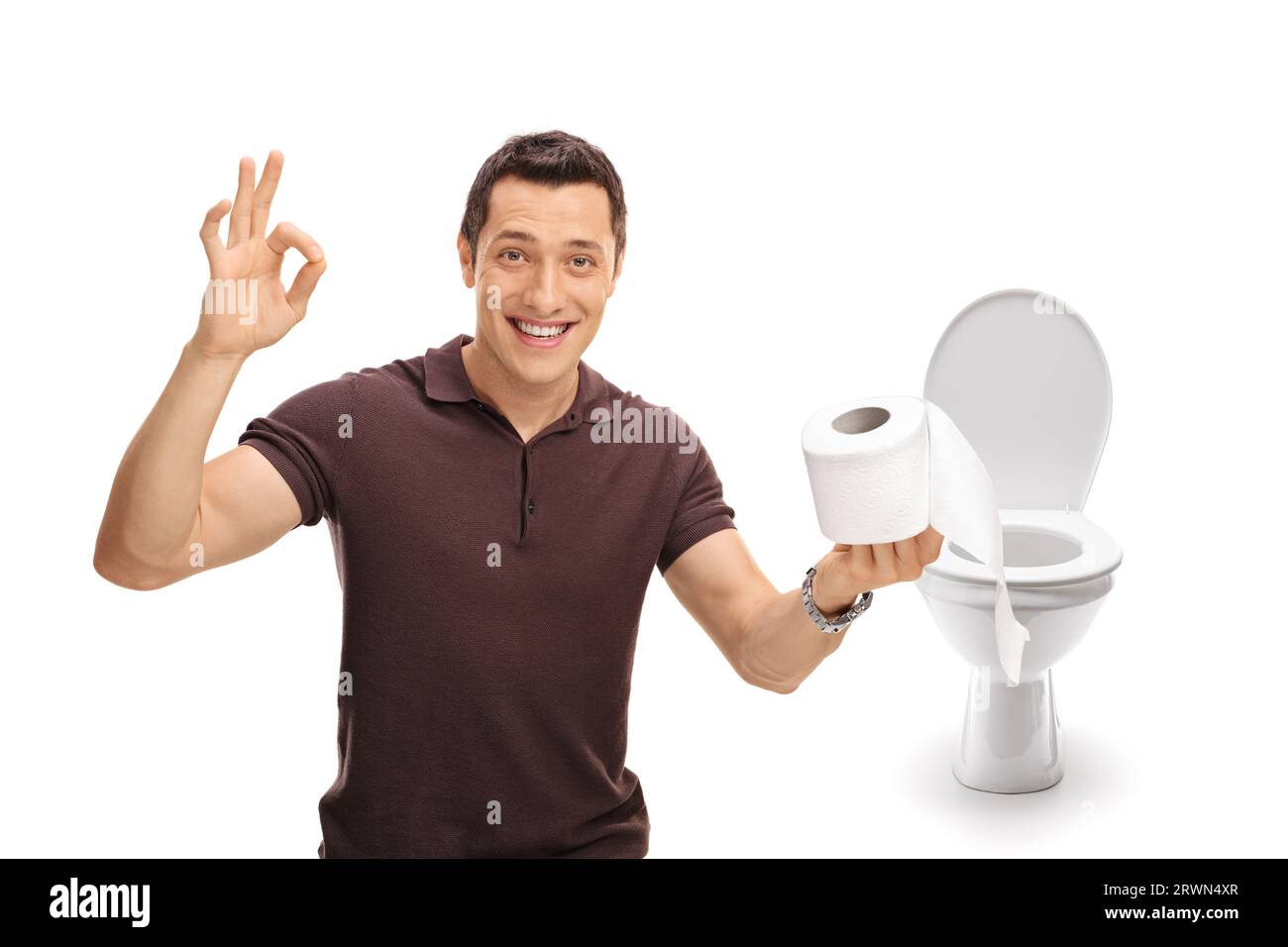 Smiling young man holding a toilet paper roll in a toilet isolated on ...