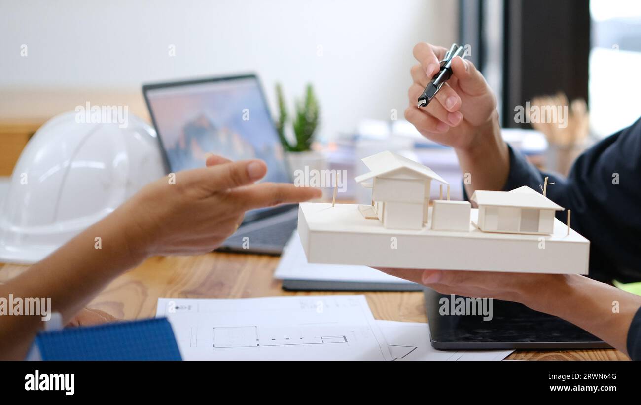 Engineer working on table and explain to customers Stock Photo - Alamy