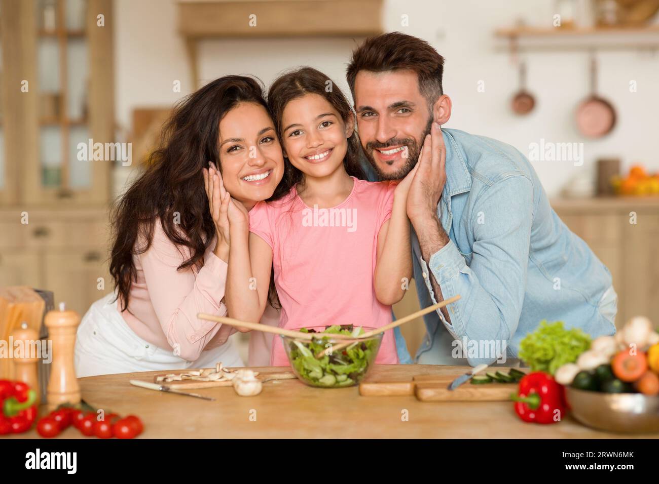 Happy european family of three making fresh vegetable salad, cooking ...