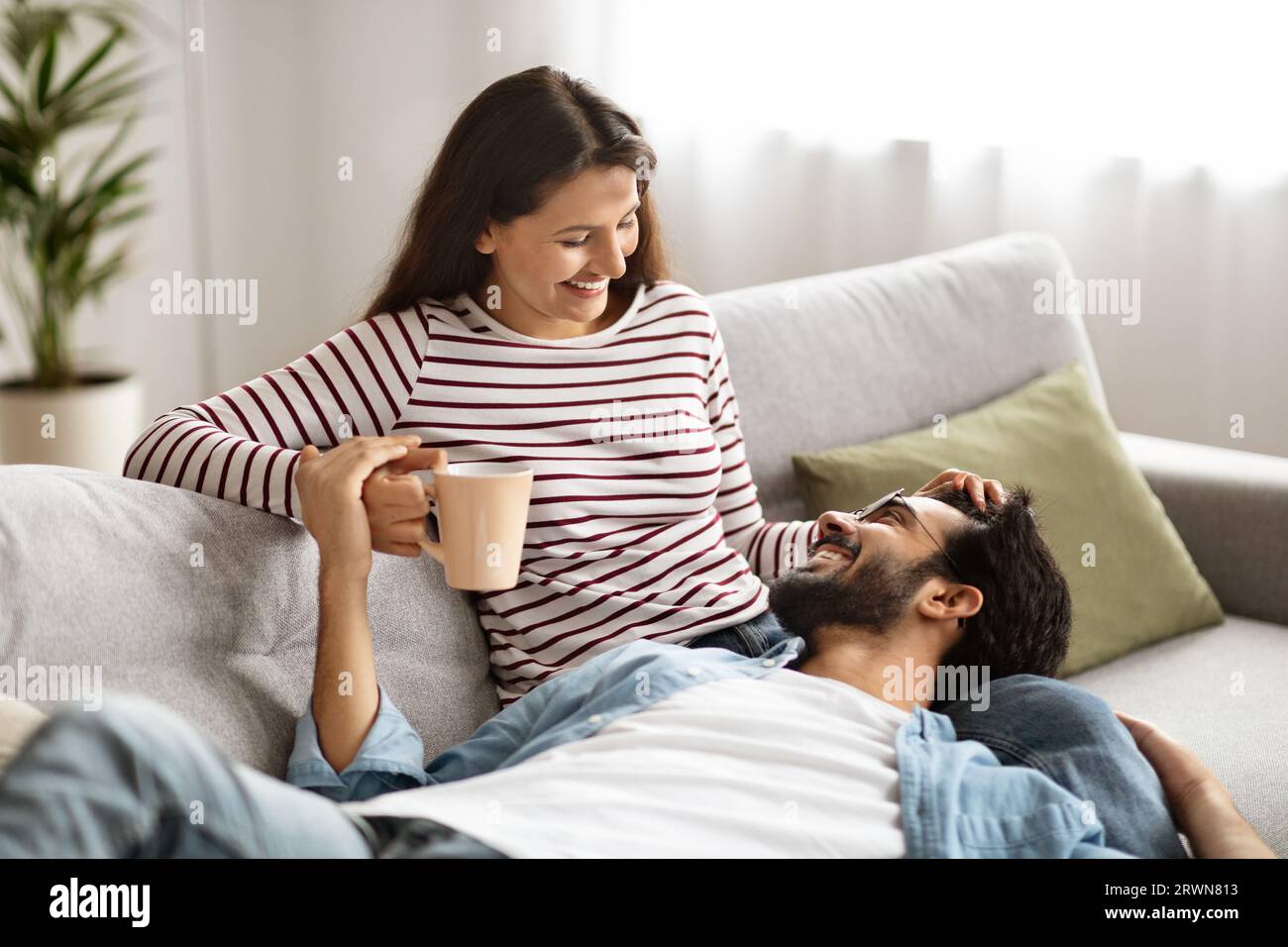 Sweet indian millennial couple cuddling at home, have conversation ...