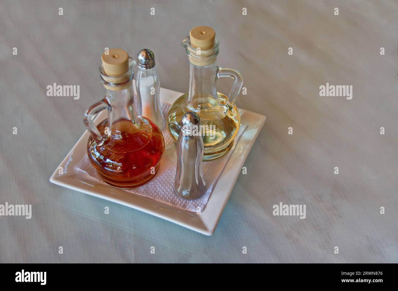 Glass condiment set with olive oil, vinegar, salt and pepper on kitchen ...