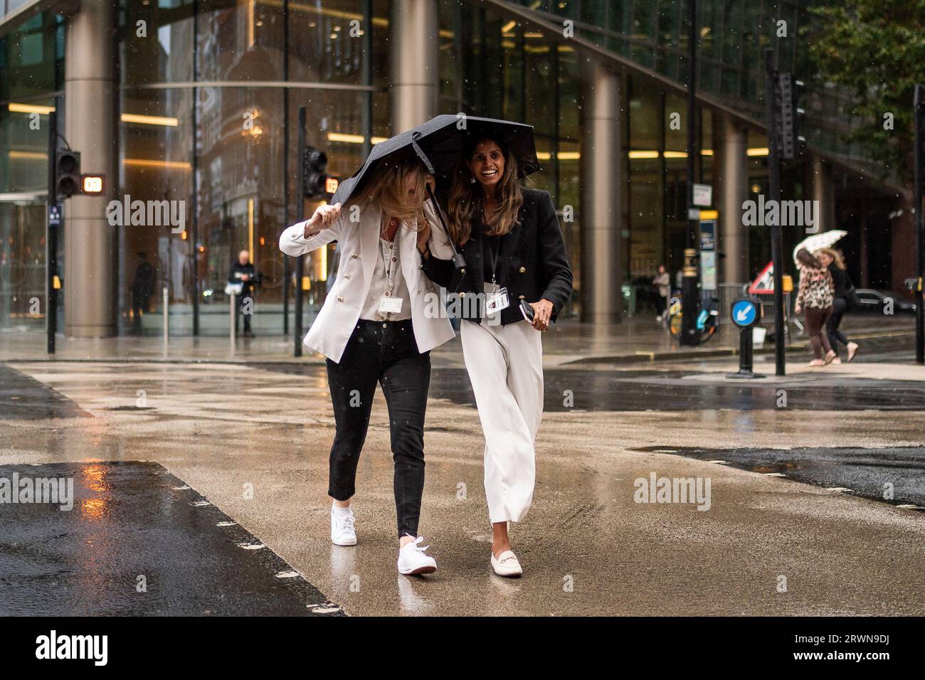 People walk through the rain and wet weather in Victoria, London ...