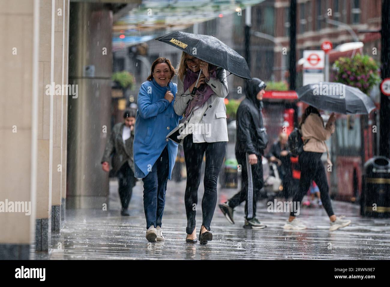 People walk through the rain and wet weather in Victoria, London ...