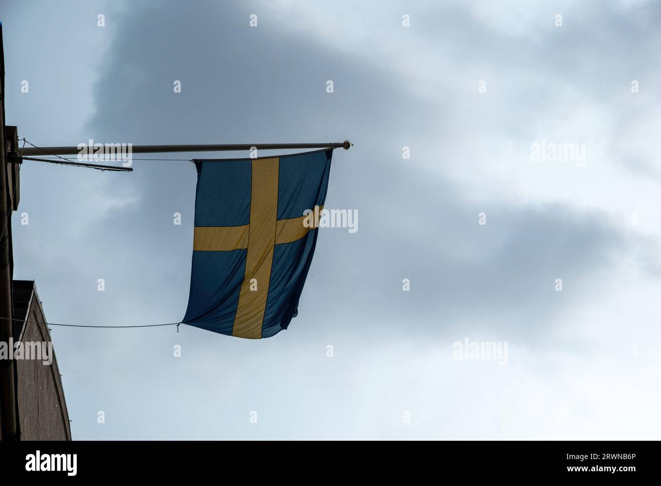 Sweden national flag waving on a Stockholm city building facade, cloudy ...