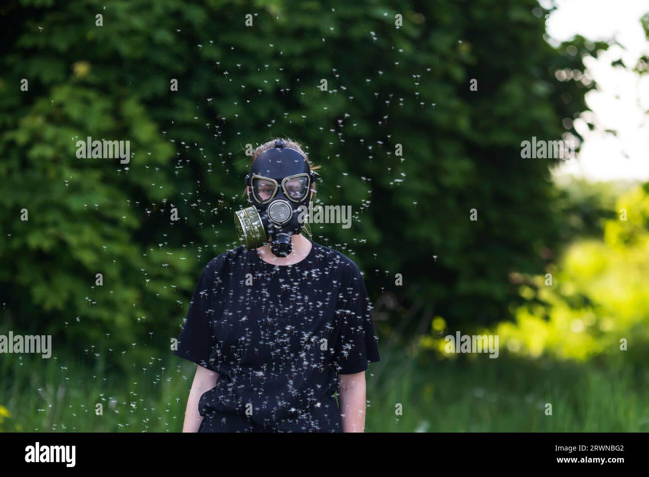 girl in a gas mask protects herself from allergies from flying ...