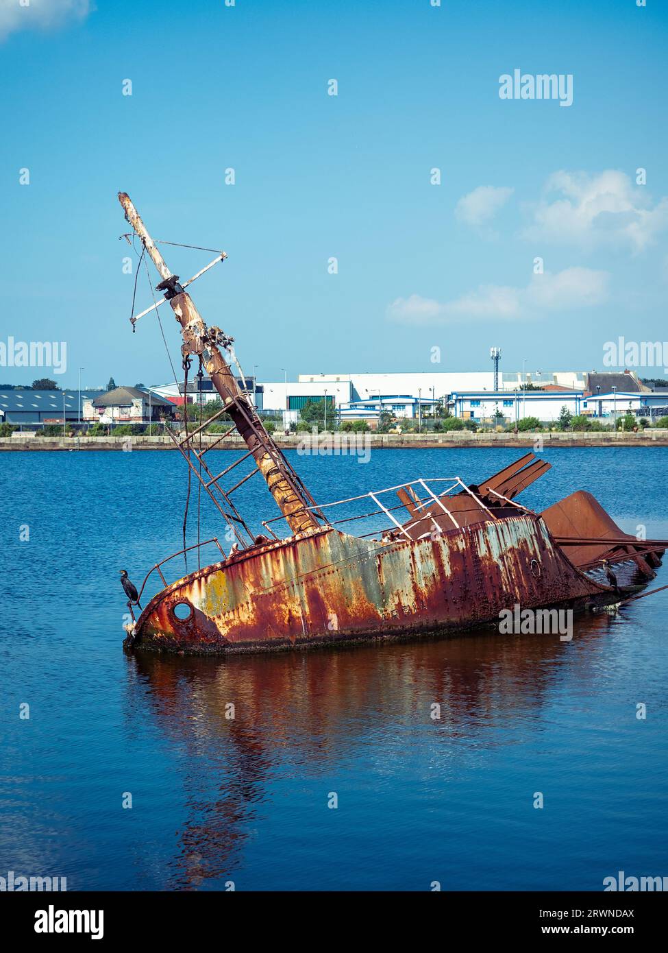 Old rusty hull of boat listing in the water at Alfred dock Birkenhead ...