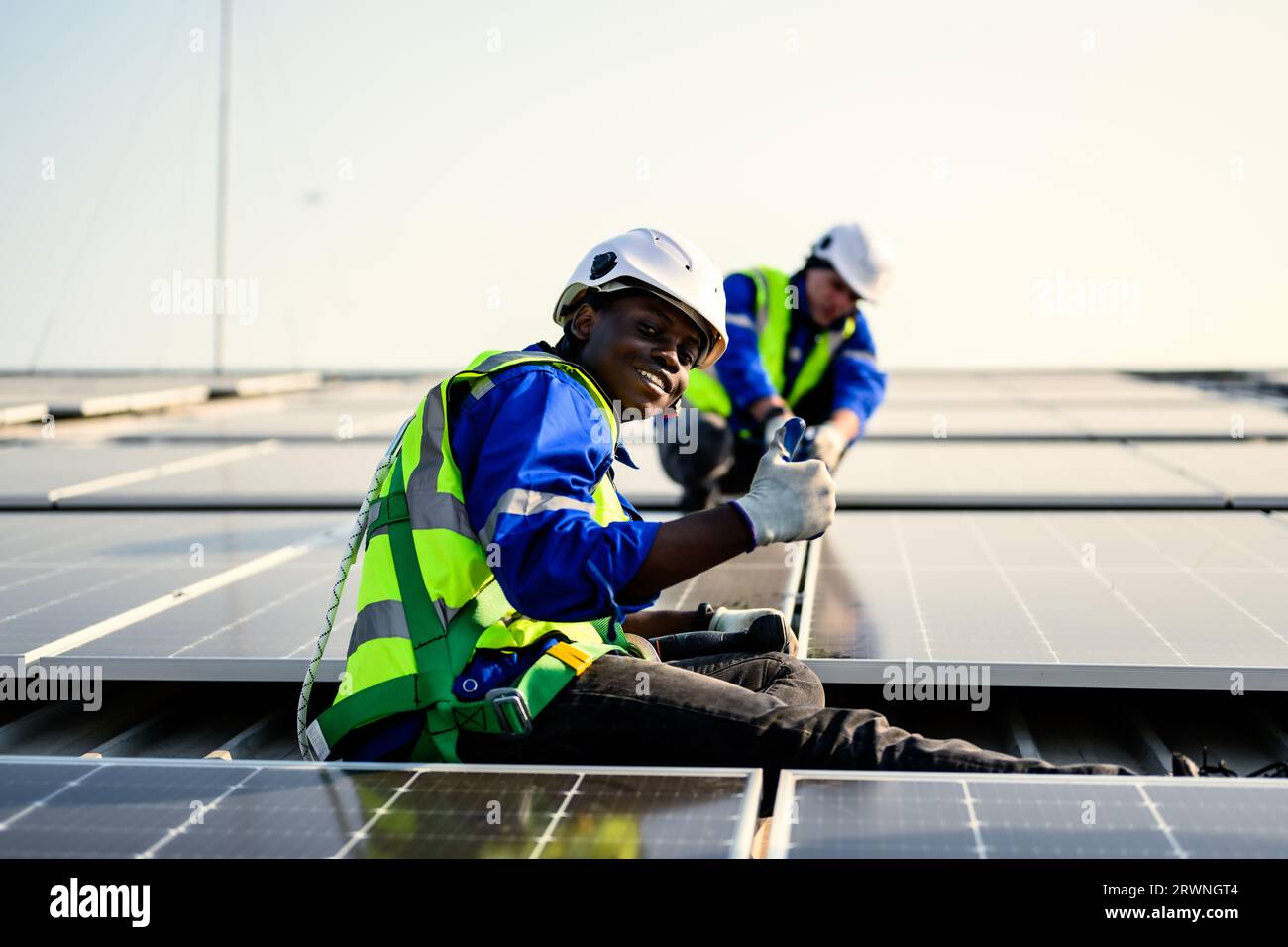 Maintenance technicians installing solar panels at solar cell farm ...