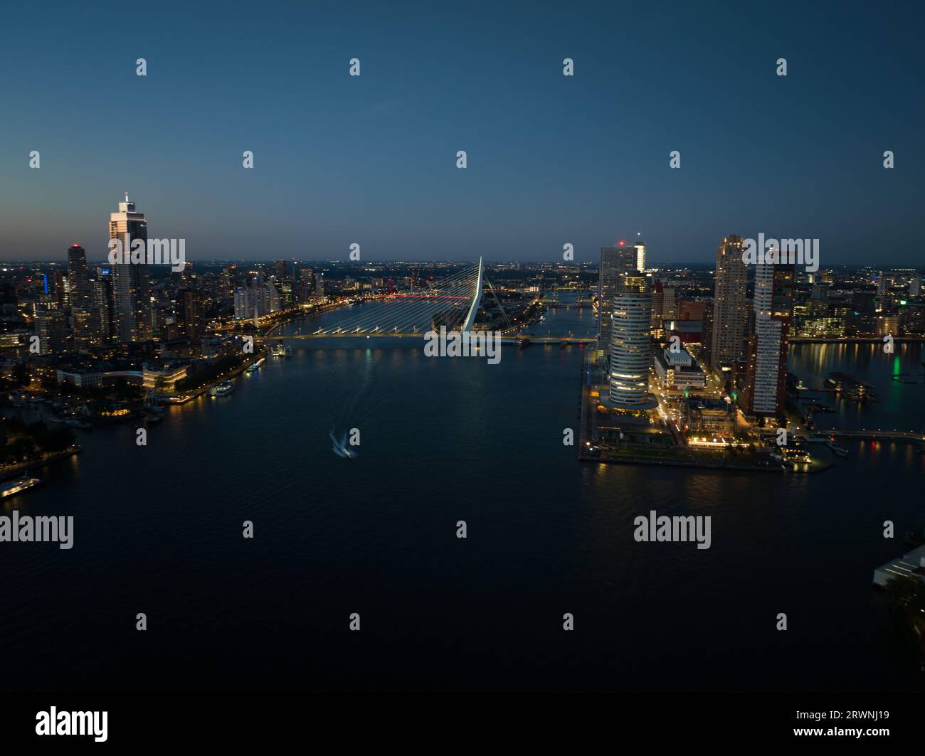 Aerial drone view of the skyline of Rotterdam at night, showcasing the ...