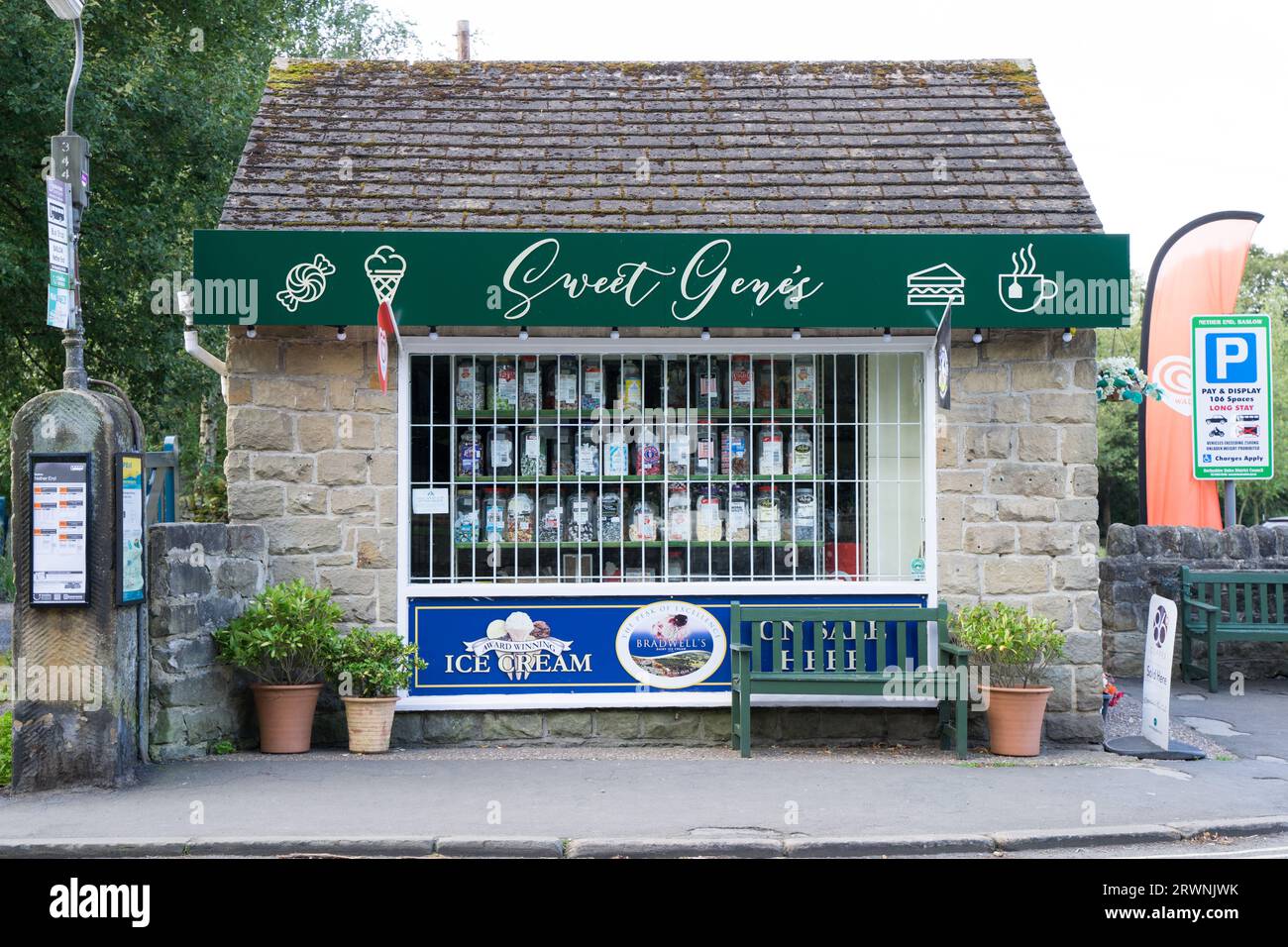 side view of detached stone built shop with white lettering on green ...