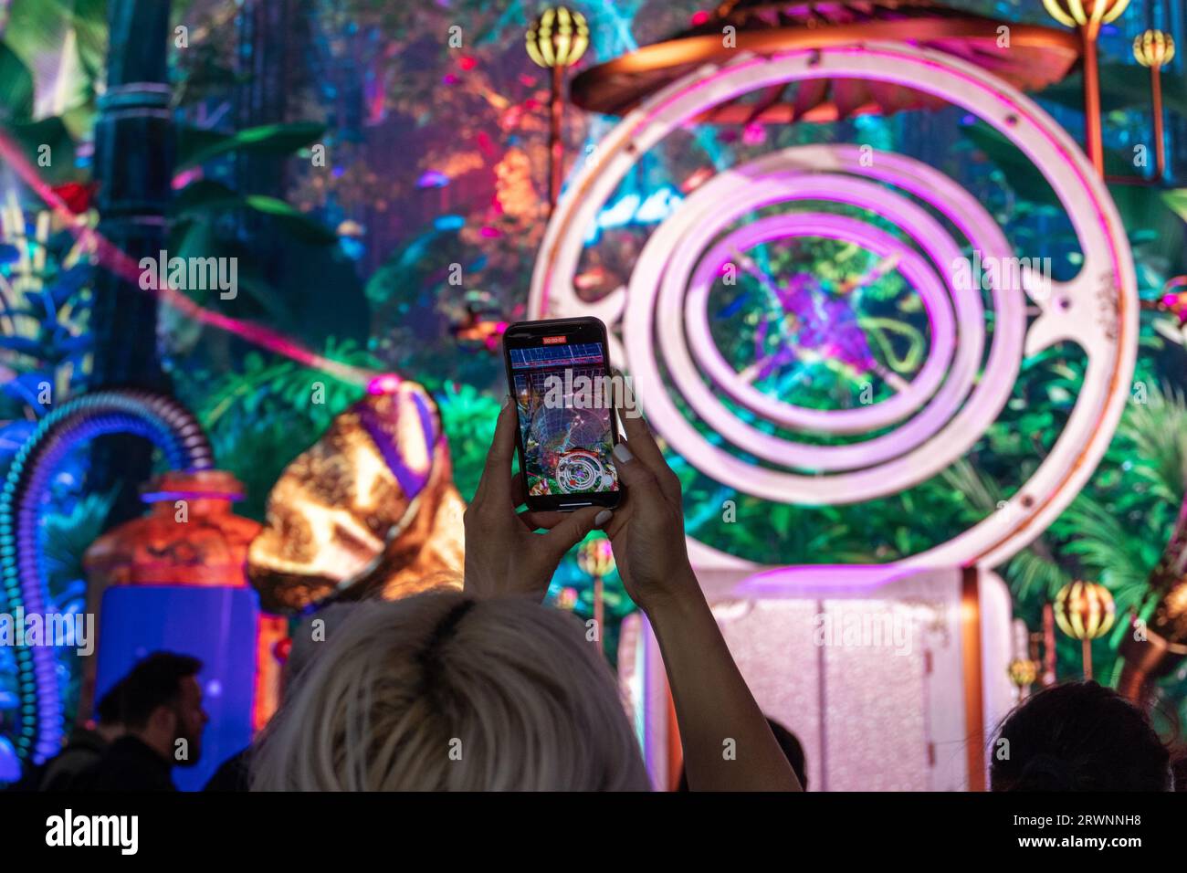 A visitor takes pictures at the "The Butterfly Trail" event. Outernet ...