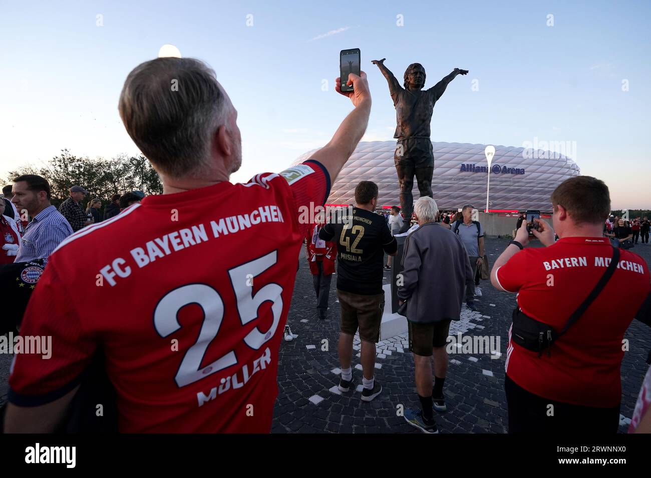 Bayern Munich fans next to the Gerd Muller statue outside the stadium ...
