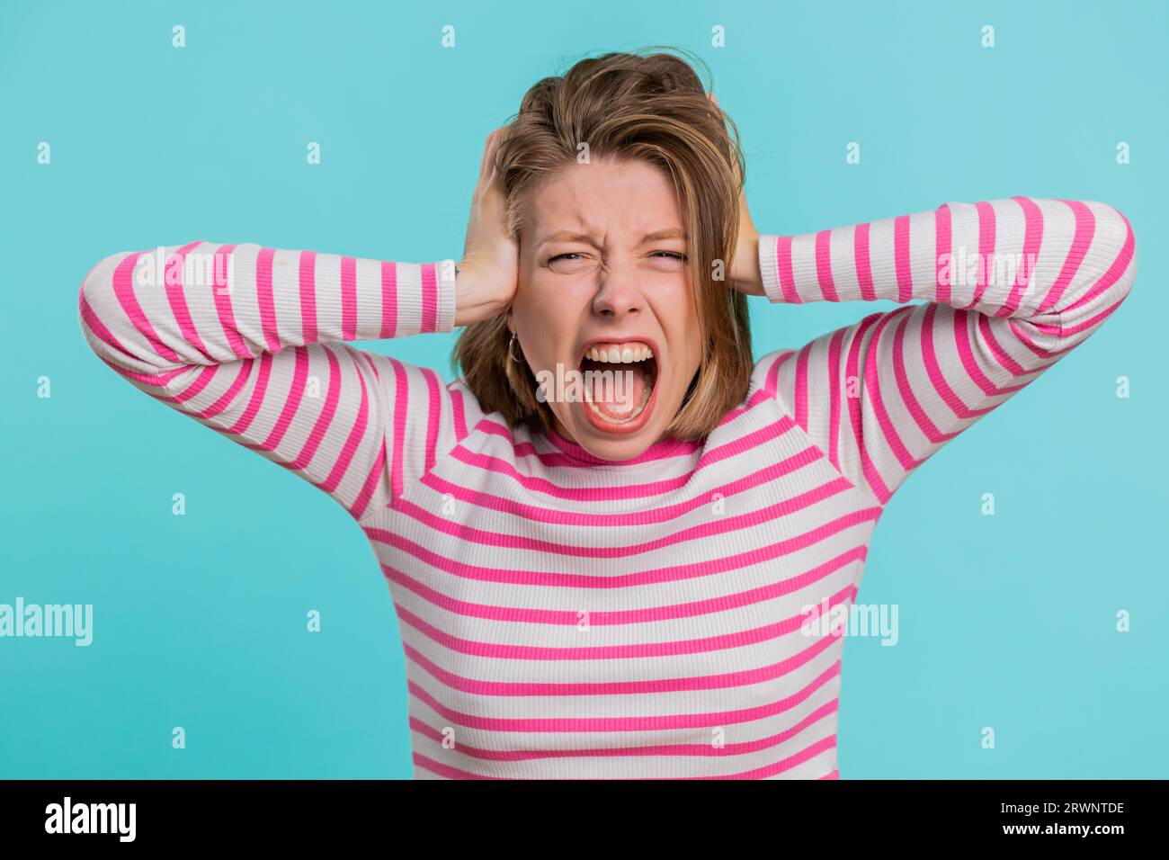 Young woman screams yell shout from stress tension problems feels ...