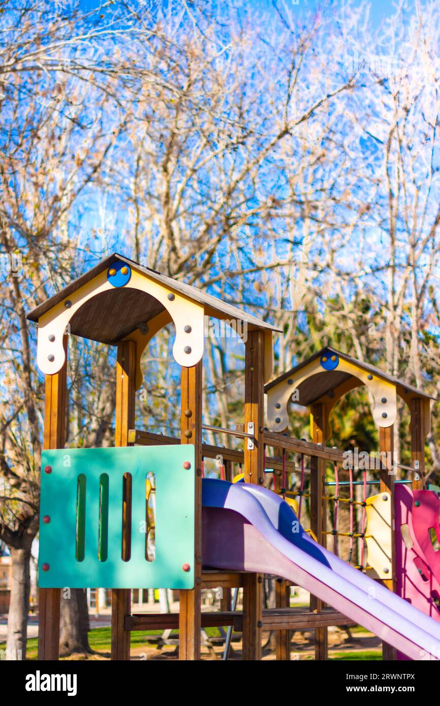 Games on a playground with a slide, between trees in a park Stock Photo ...