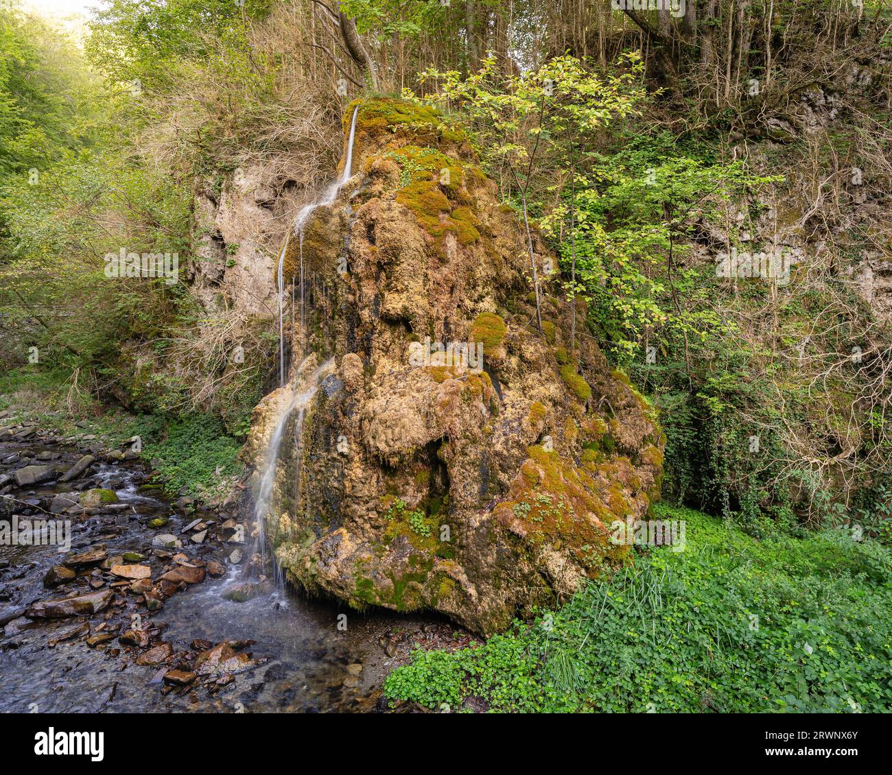 Scenic landscape view of waterfall on rock covered in limestone and ...
