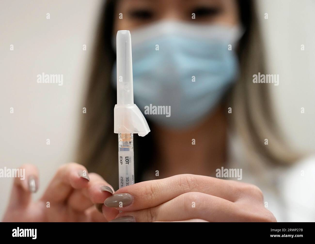 Pharmacist Kim Nguyen prepares to administer a Moderna Spikevax COVID ...