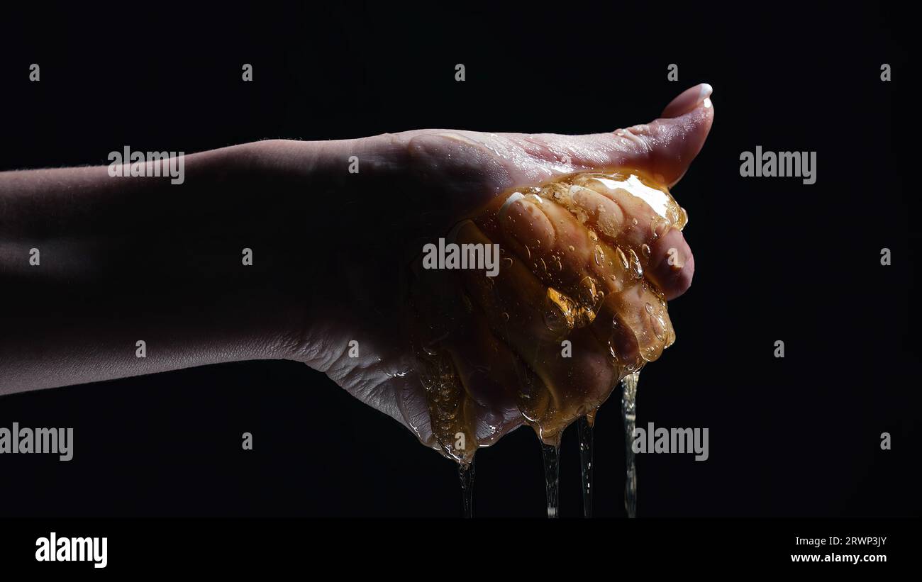Woman hand squeezes honeycombs full of honey. Dripping,pouring tasty ...