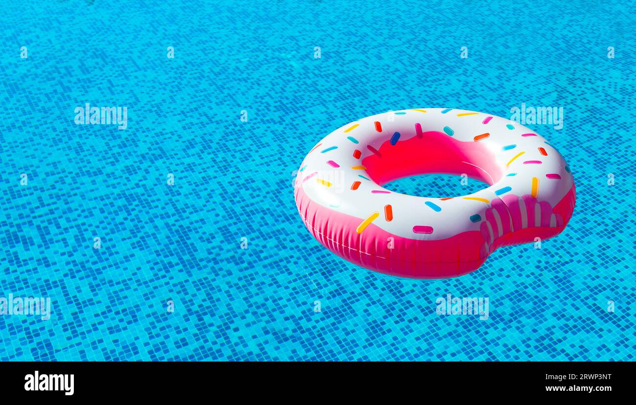 Inflatable colorful rubber donut float ring in swimming pool on sunny ...