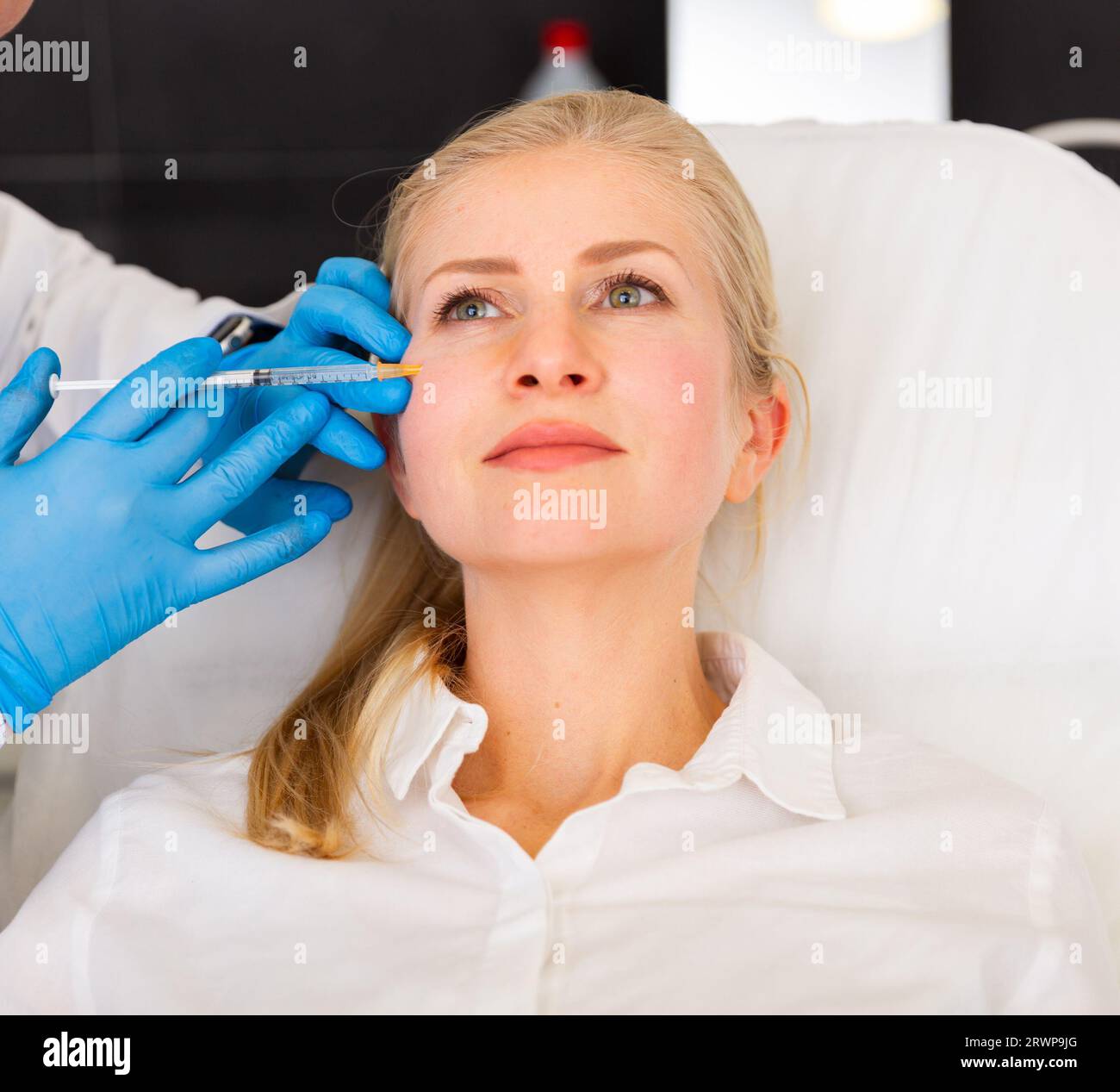 Woman getting filler injections for facial skin tightening at ...